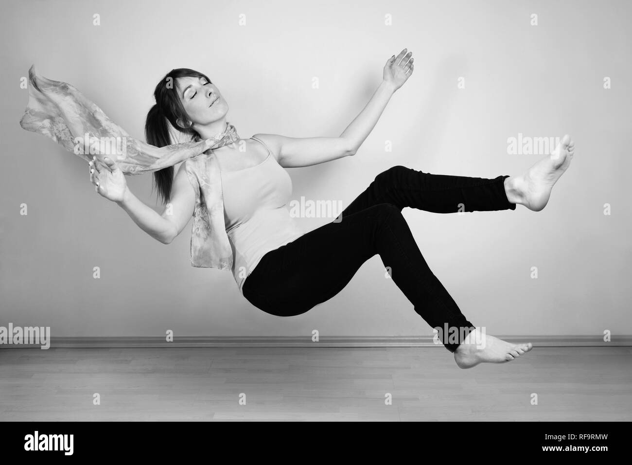 Young woman levitating in empty room Stock Photo - Alamy