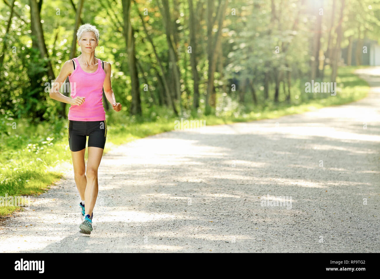 Fit caucasian woman jogging in nature Stock Photo - Alamy