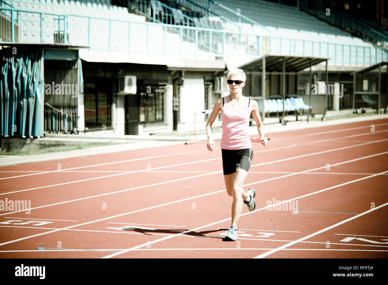 Fit caucasian woman running on stadium Stock Photo - Alamy