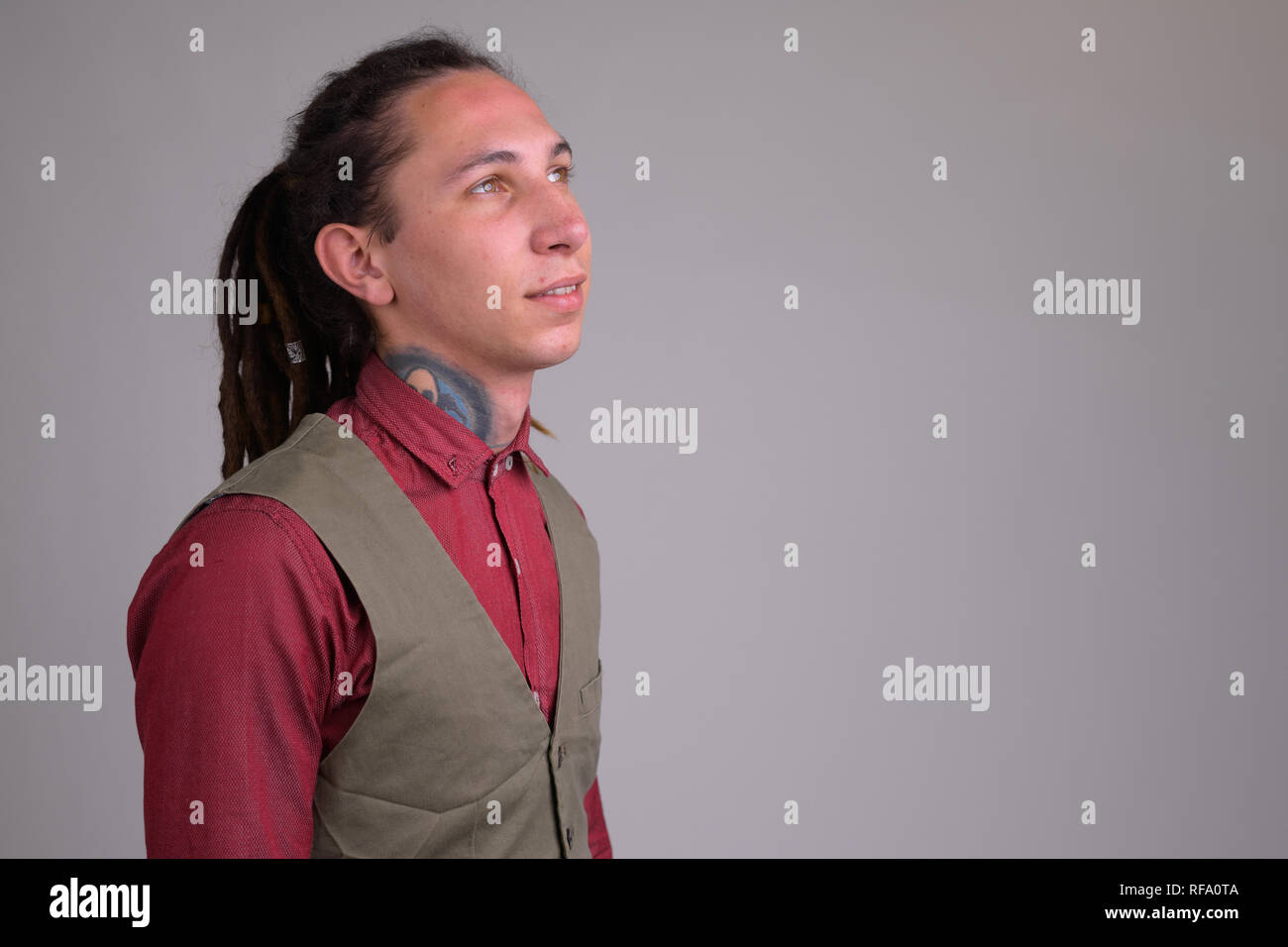 Face of young happy businessman with dreadlocks thinking Stock Photo ...