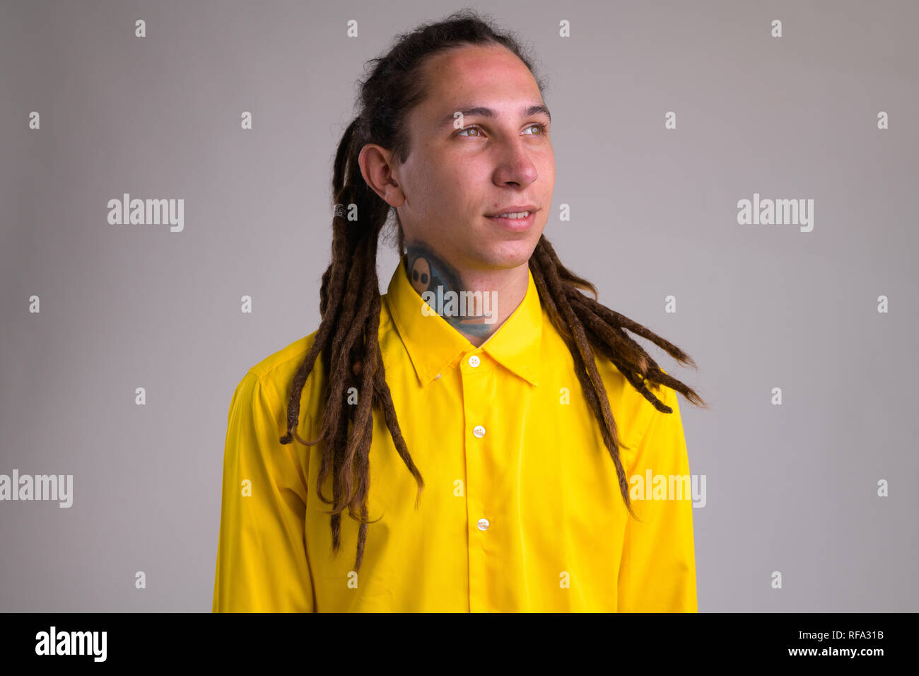 Face of young happy businessman with dreadlocks thinking Stock Photo ...