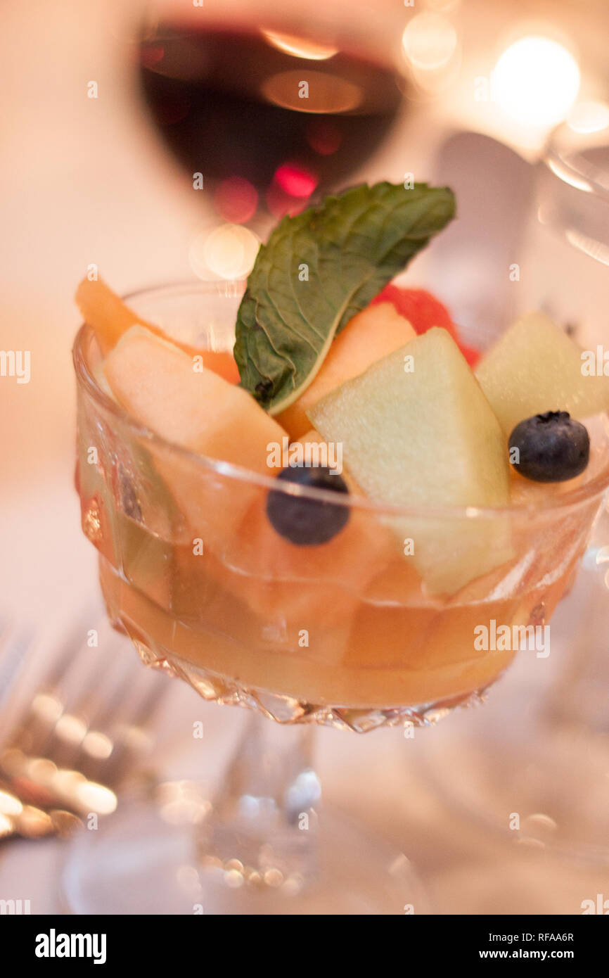 Dessert fruit salad in a crystal serving glass, at a formal dinner ...