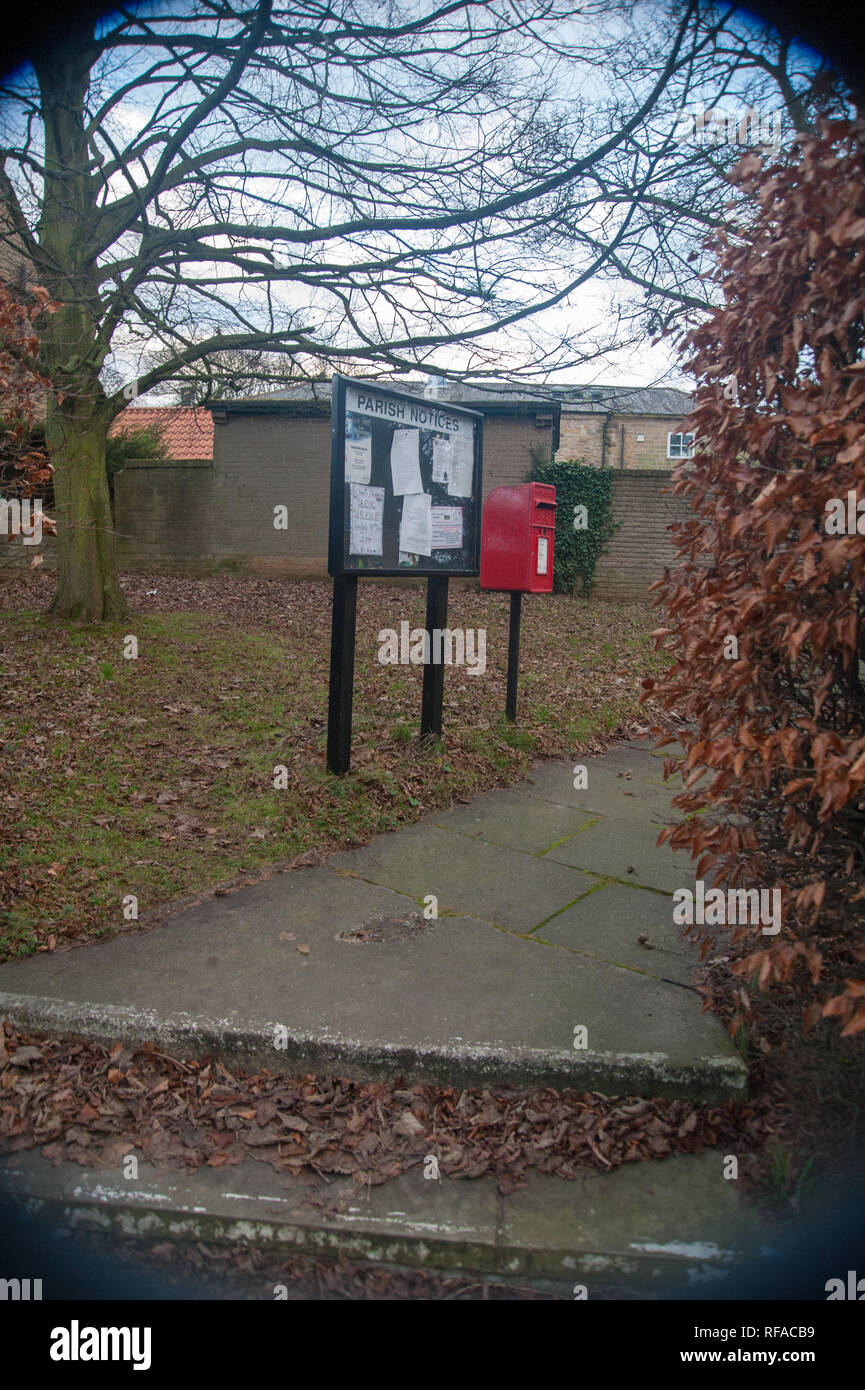 a rural village notice board and red post box beside a footpath and ...