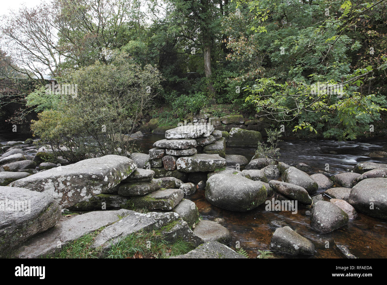 Clapper bridge near the confluence of the East and West Dart rivers ...