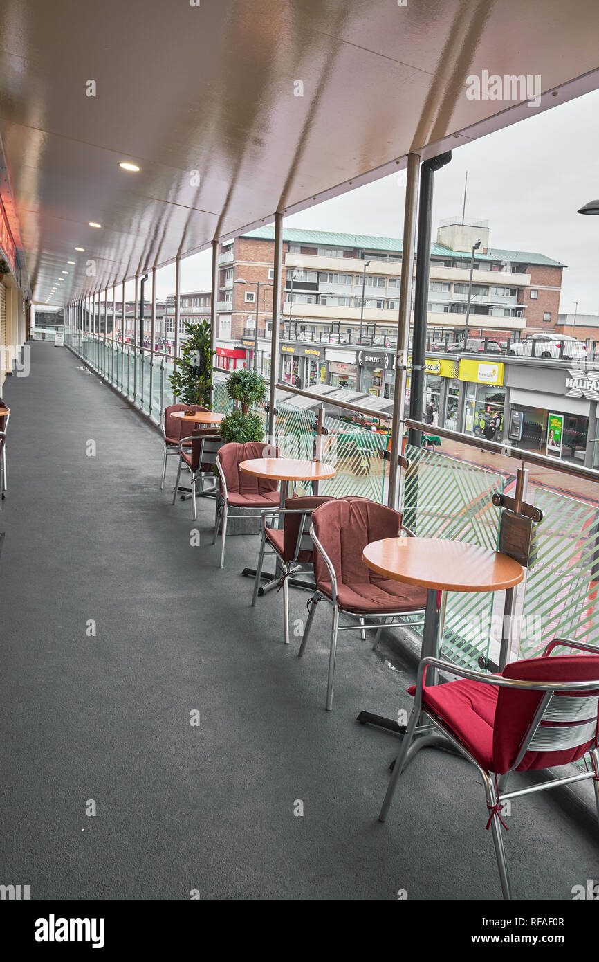 Tables and chairs of a cafe on the balcony above the shops in ...