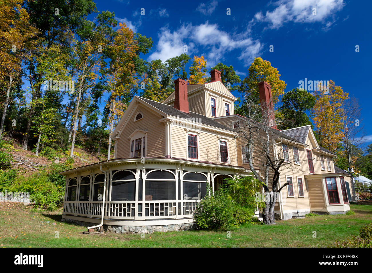 The Wayside House standing below a blue sky and autumn trees. Minute ...