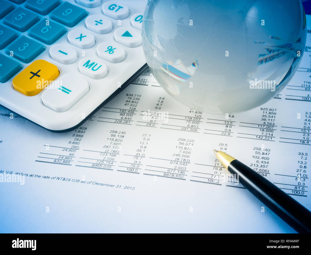 A close-up shot of a calculator. A printed balance sheet and a pen are ...