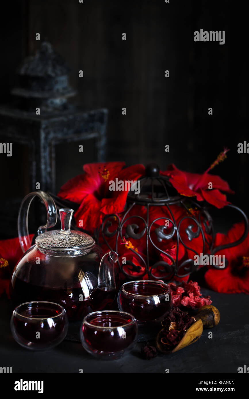 Herbal hibiscus tea carcade with red hibiscus flowers. Dark mood photo ...