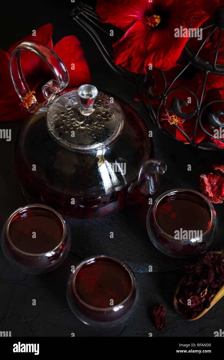 Herbal hibiscus tea carcade with red hibiscus flowers. Dark mood photo ...