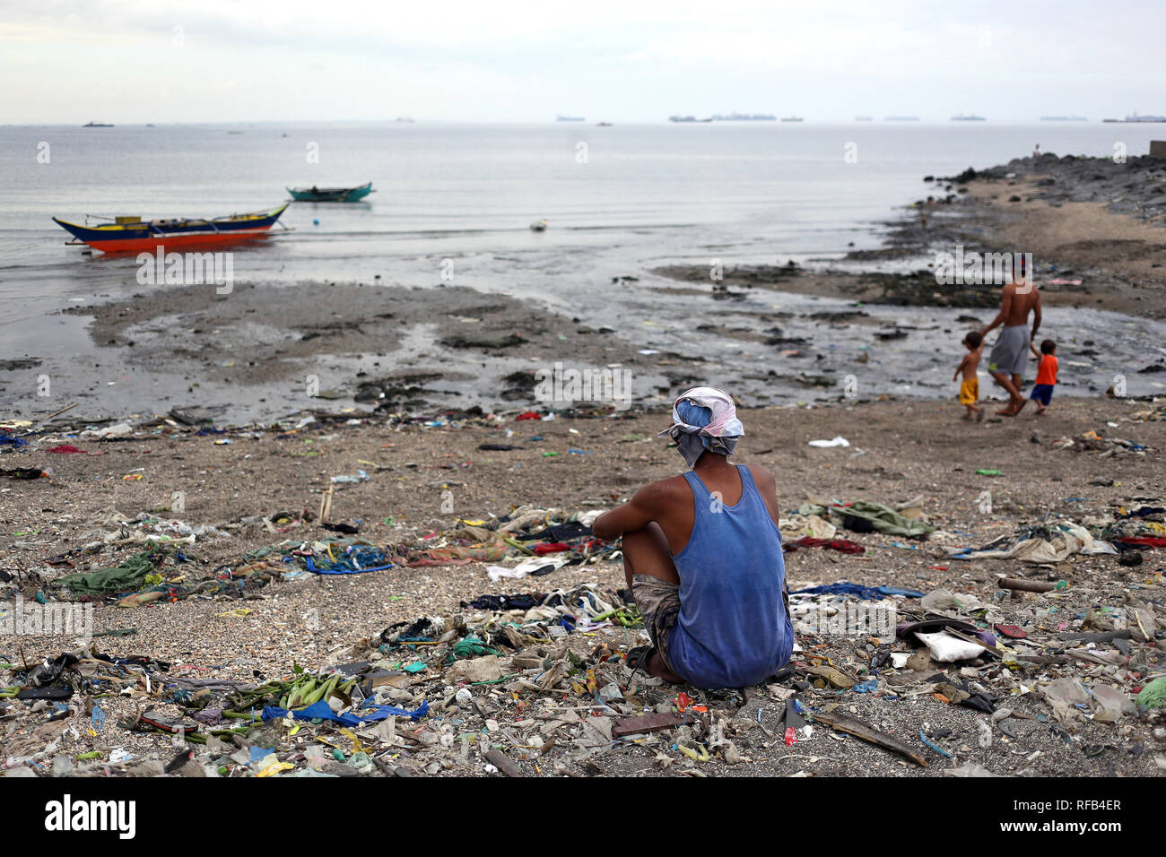 Manila, Philippines. 25th Jan, 2019. A man sits between garbage in ...