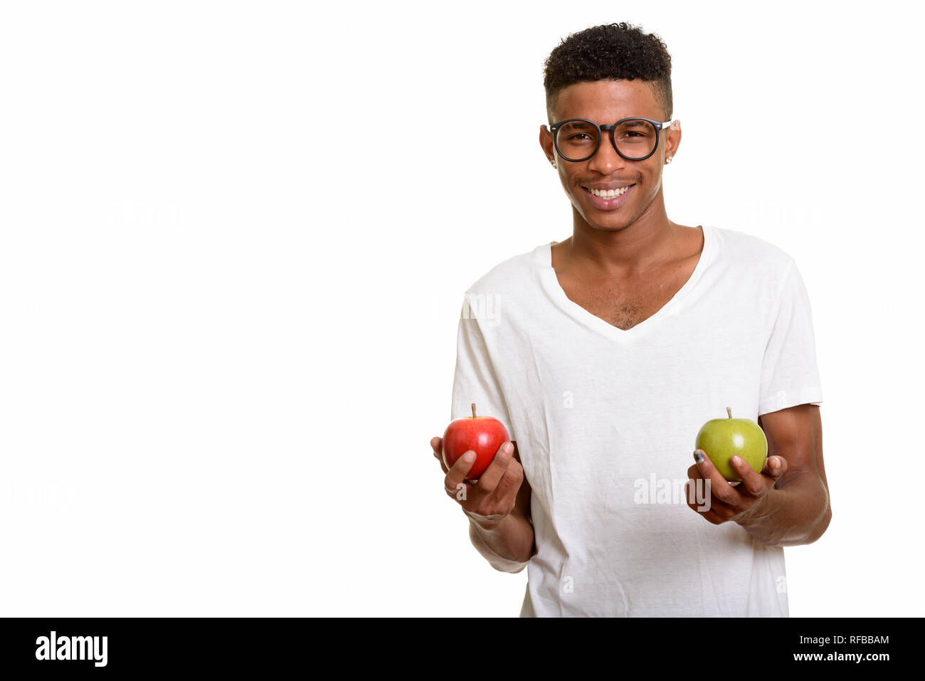 Young happy African man holding red and green apple Stock Photo - Alamy