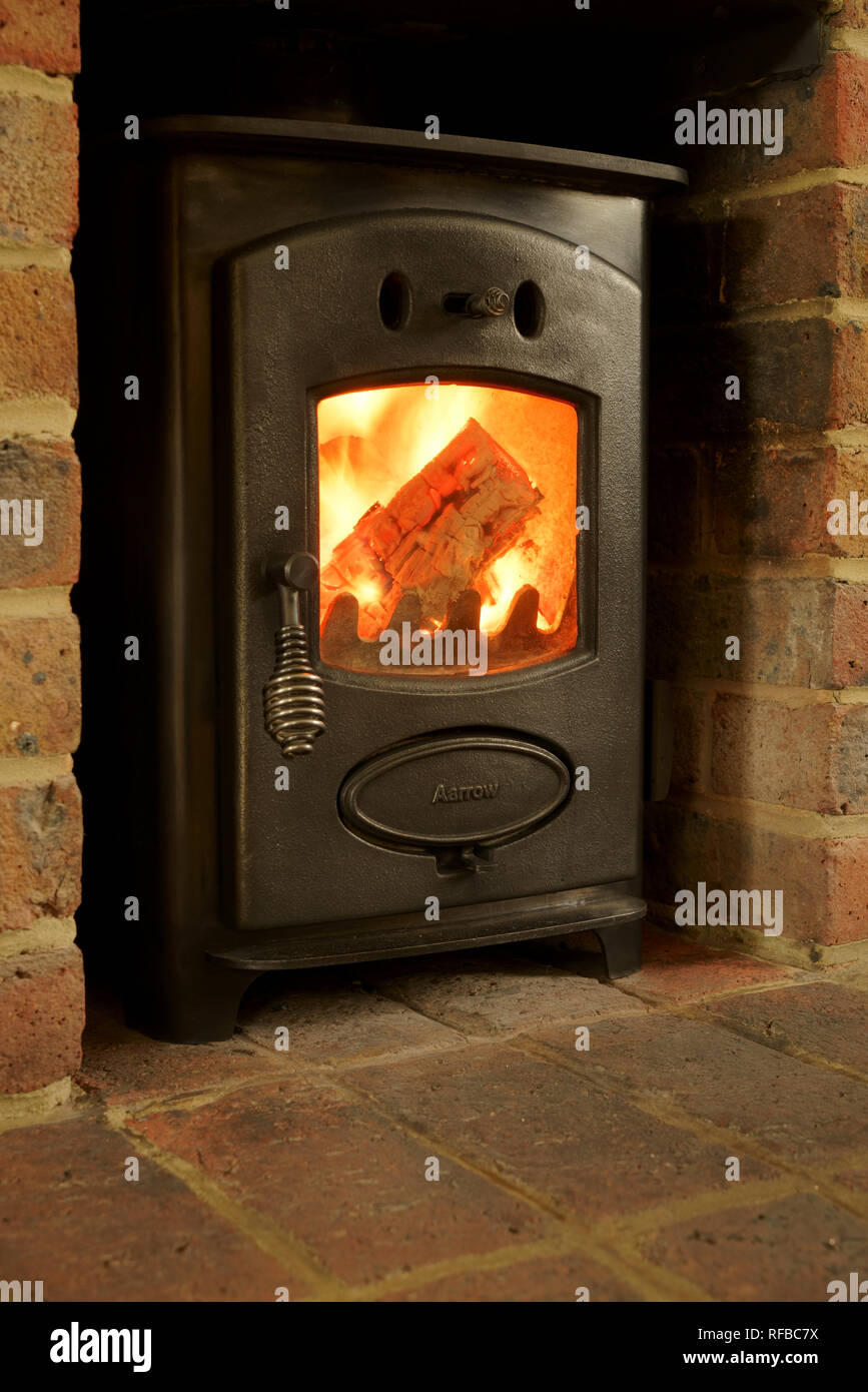 Woodburning stove with glowing fire in a brick fireplace Stock Photo ...
