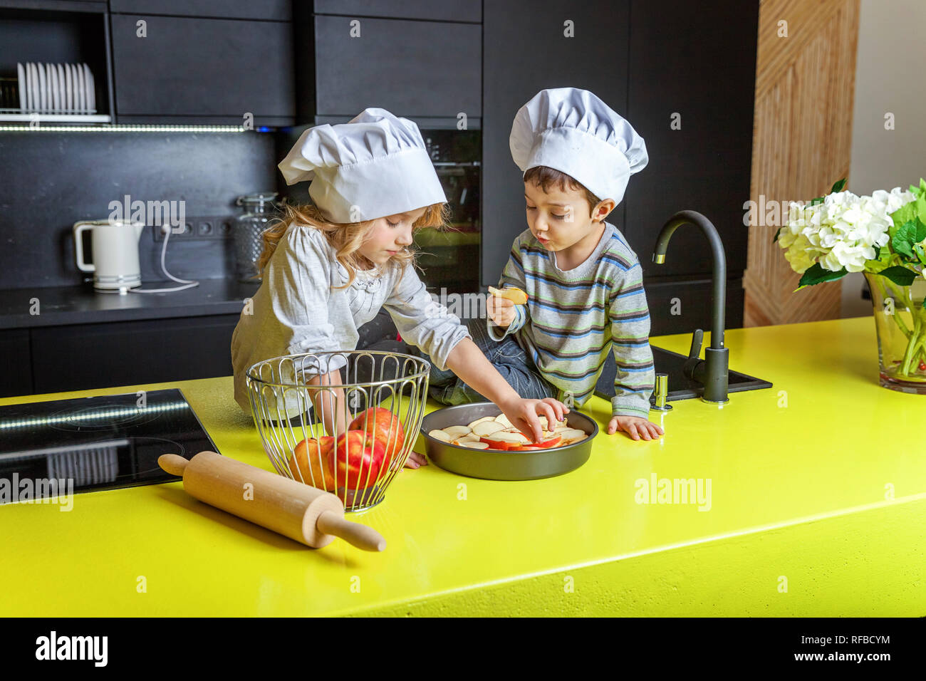 Little kids girl and boy with chef hat preparing bake homemade apple ...