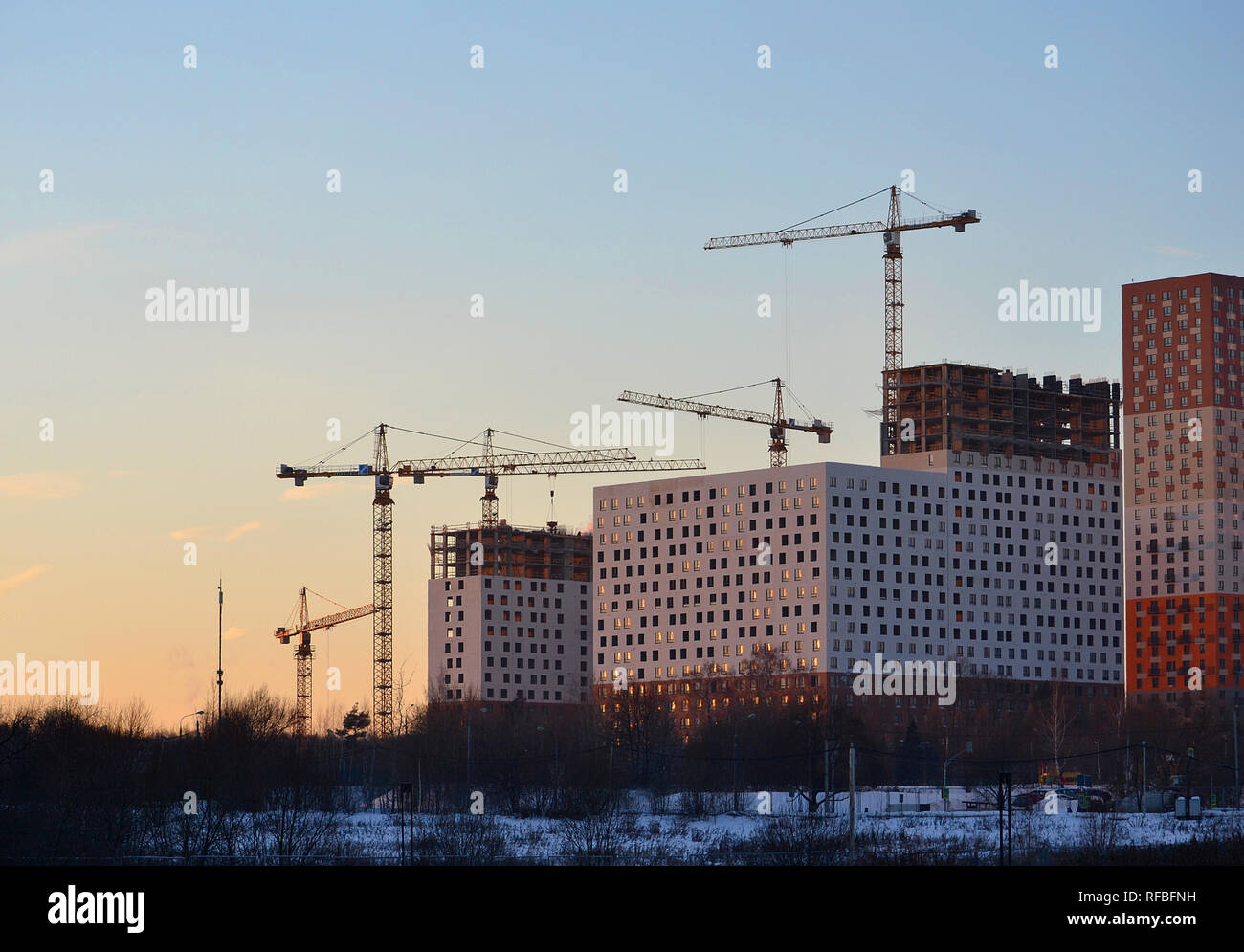 building cranes at the background of cubic building under construction ...