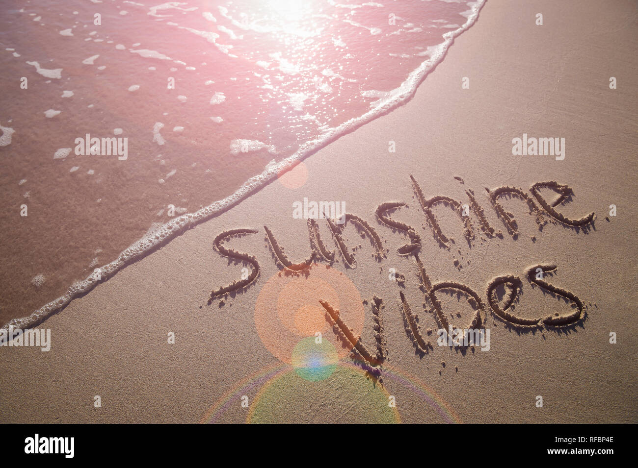 Sunshine Vibes tropical vacation message handwritten on a smooth sand ...