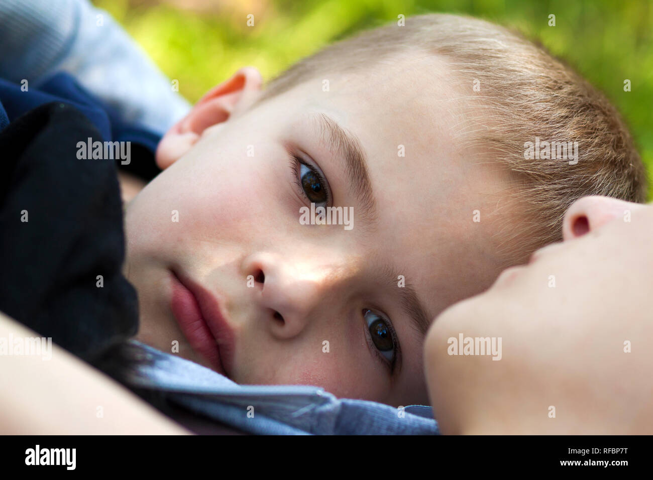 Close-up portrait of cute handsome child boy with gray dreamy eyes ...