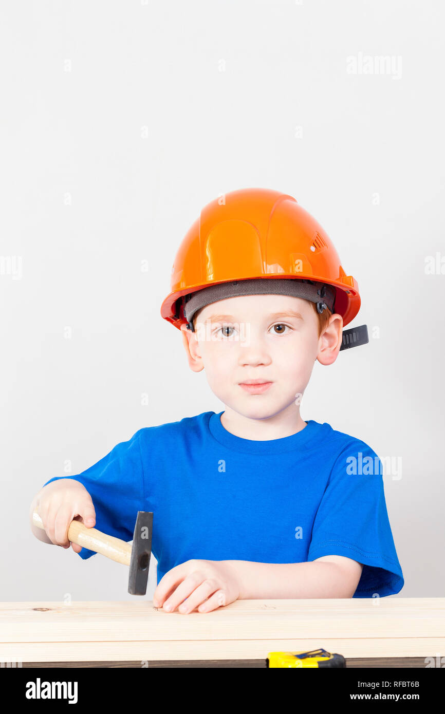 little boy with a hammer and other construction tools during work ...