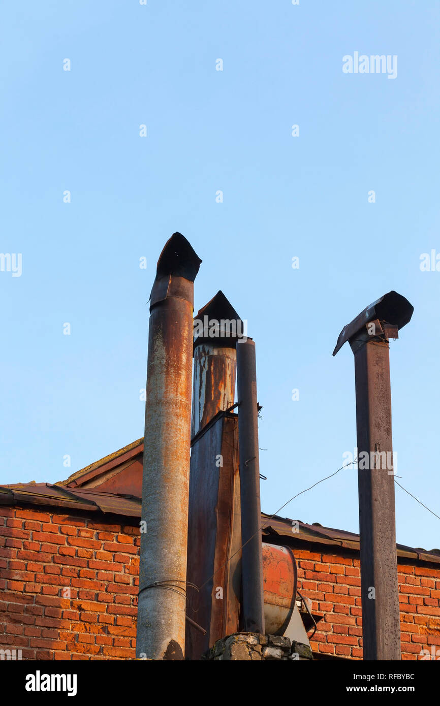 Old thick thin metal chimneys on the roof of a building closeup Stock ...