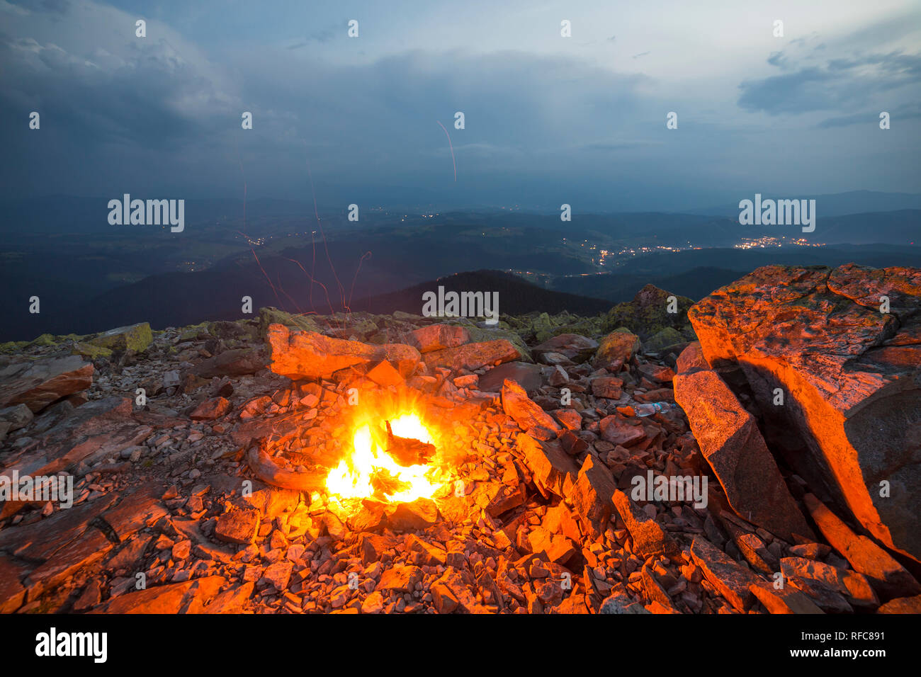 Beautiful summer night in mountains. Bright white yellow fire burning ...