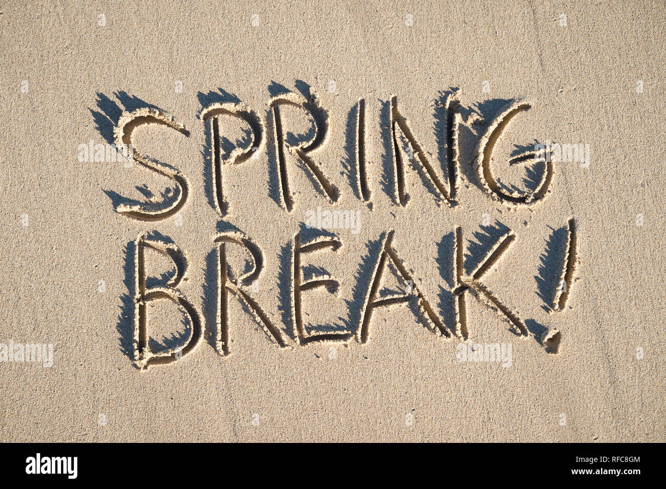 Excited Spring Break! message handwritten on the smooth sand of an ...