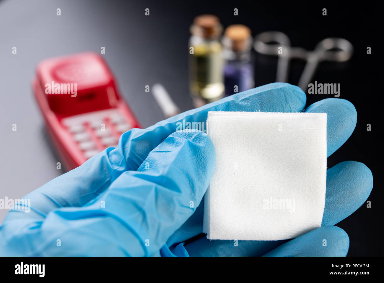A clean handkerchief in medical pliers. Old phone and medical ...