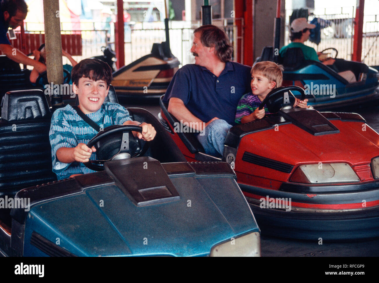 Father and His Two Sons Enjoy a Bumper Car Ride at a County Fair, USA ...