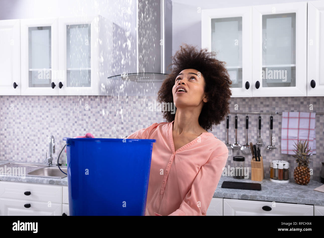 Close-up Of A Worried Young Woman Collecting Water Leaking From Ceiling ...