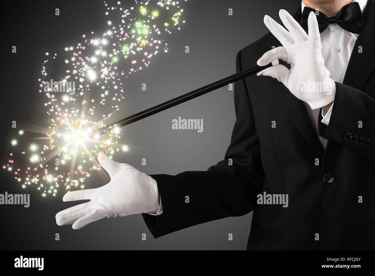 Close-up Of A Magician's Hand Creating Sparkles With Magic Wand On Grey ...