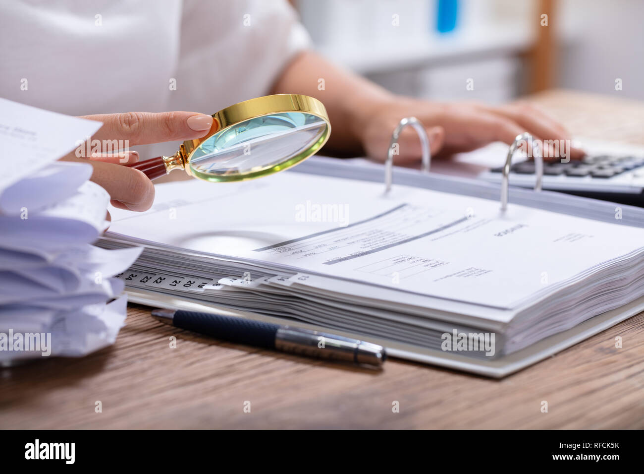 Close-up Of A Businesswoman's Hand Holding Magnifying Glass Over ...