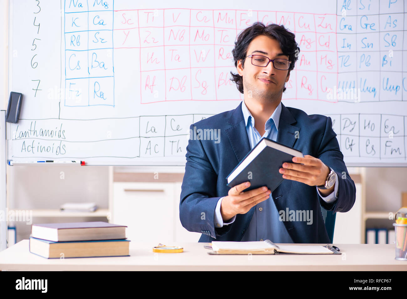 Young male chemistry teacher in front of periodic table Stock Photo - Alamy
