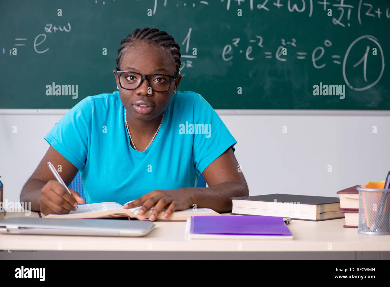 Black female student in front of chalkboard Stock Photo - Alamy