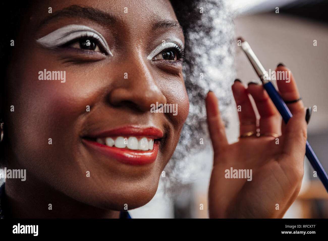 Dark-skinned african american model with bright eyeshadows smiling ...