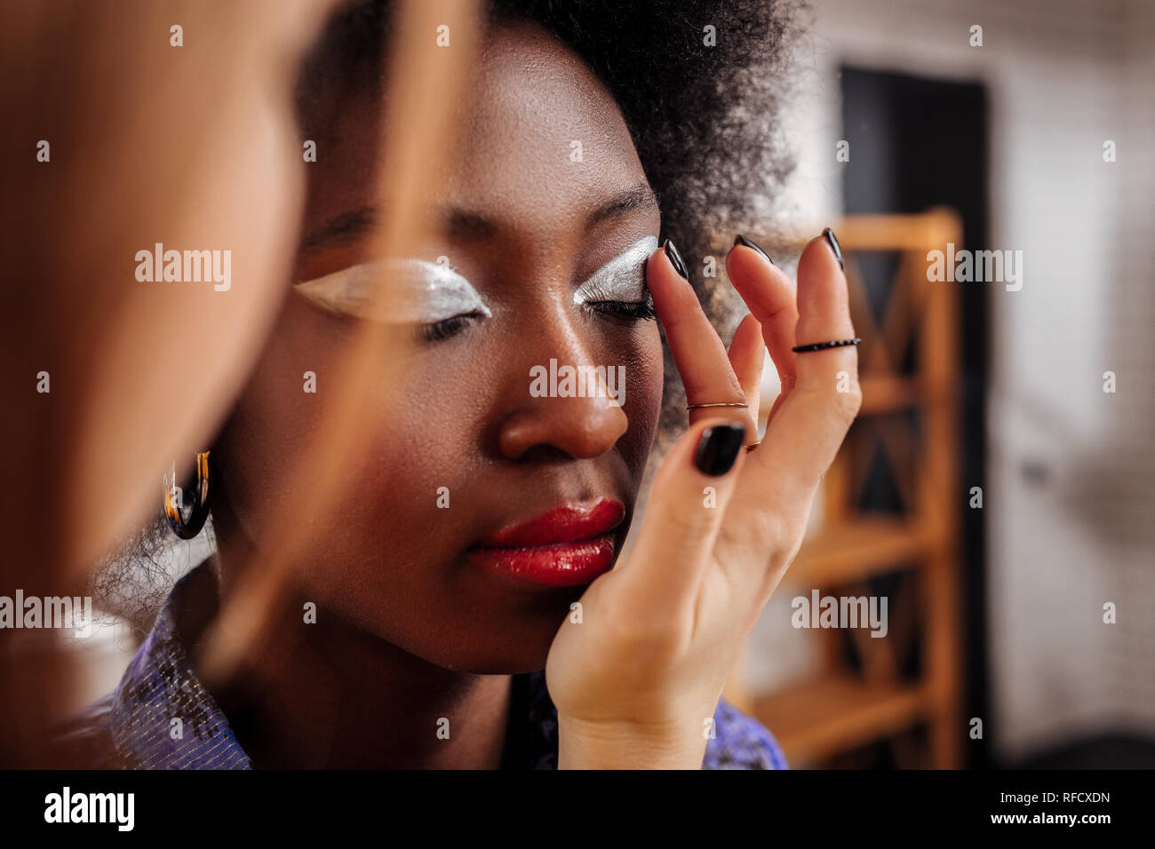 Fair-haired young stylist with black nail polish spending a day in ...