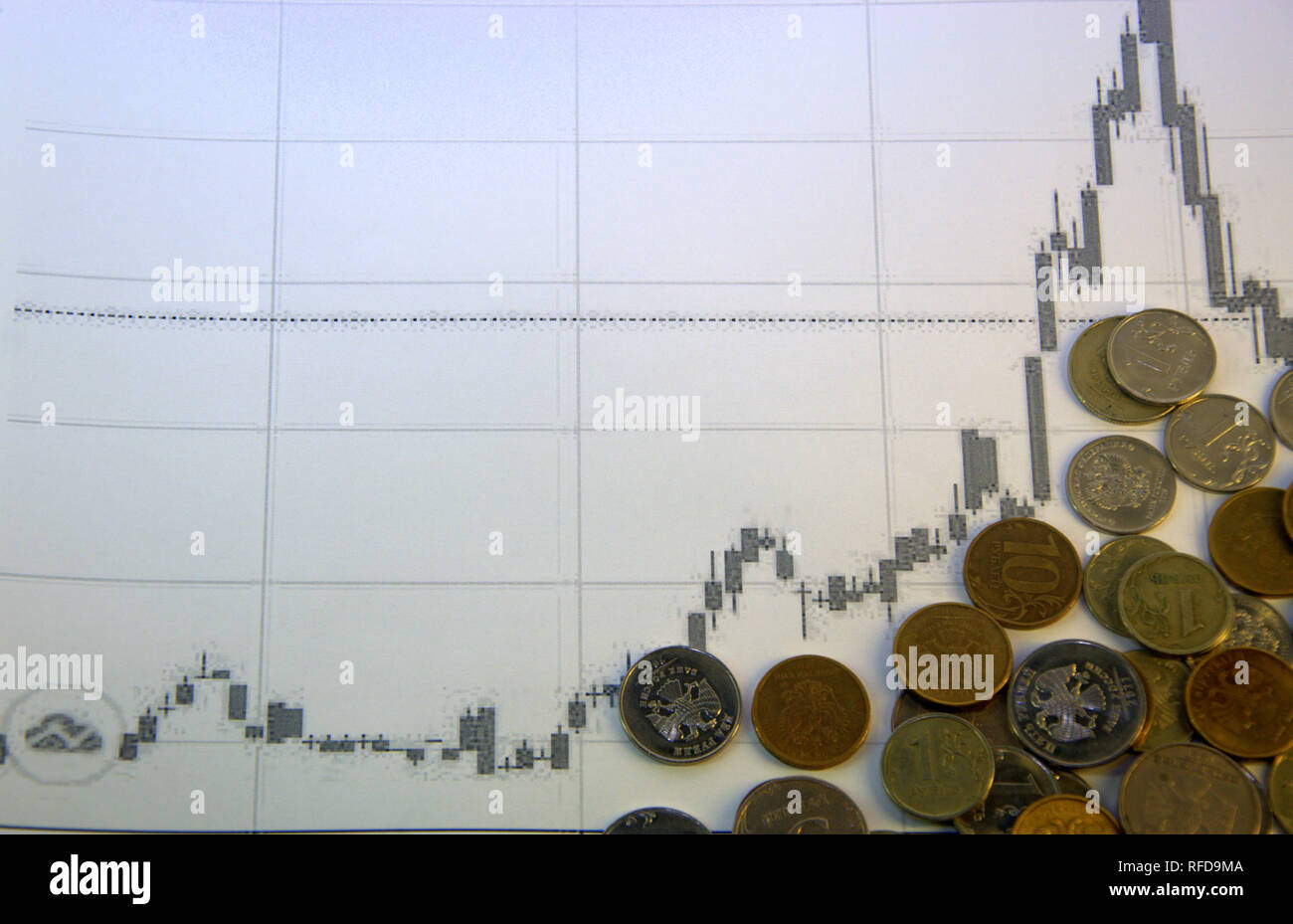 Coins scattered on the growth chart. Close up Stock Photo - Alamy