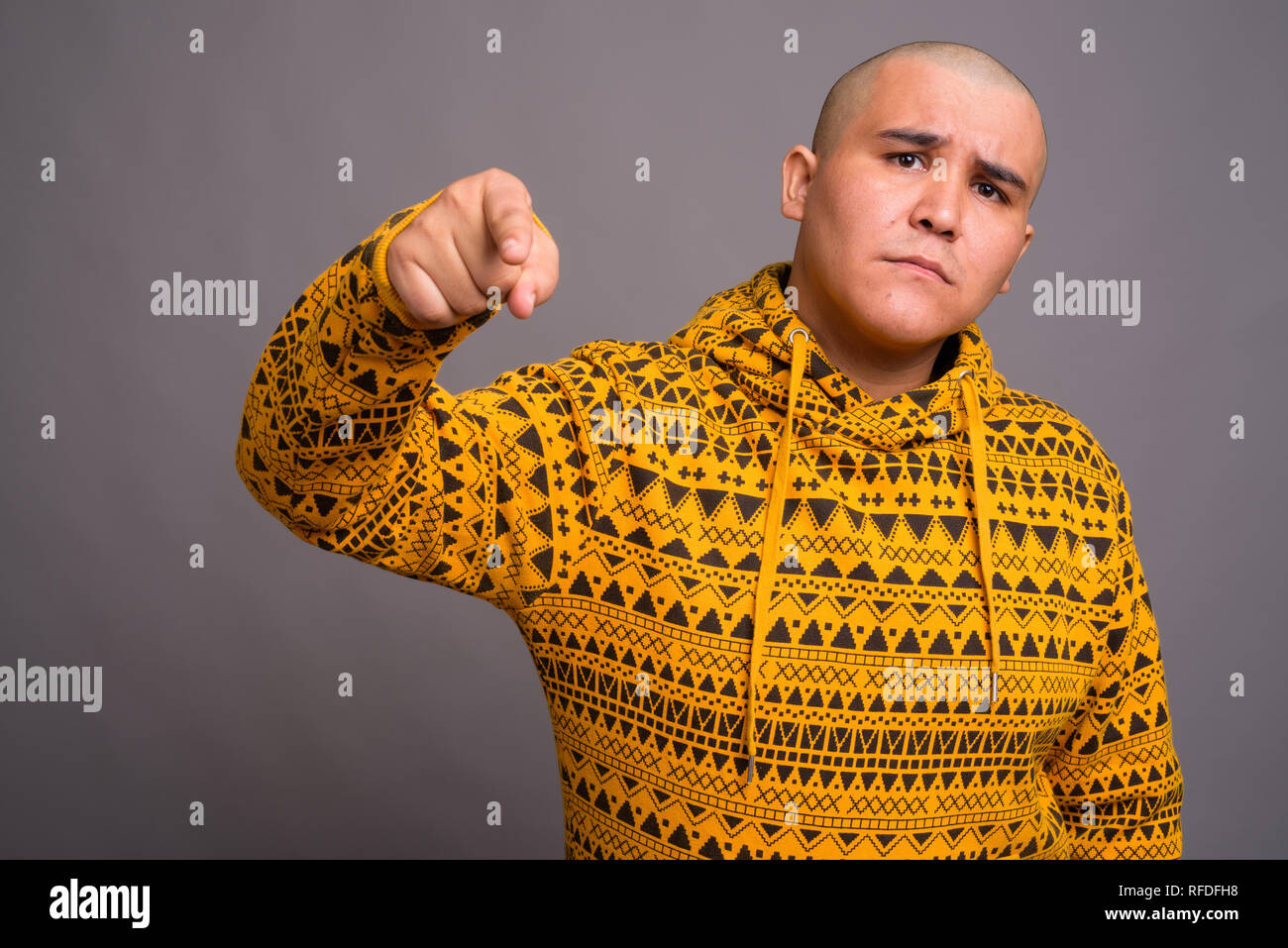 Young bald Asian man against gray background Stock Photo - Alamy