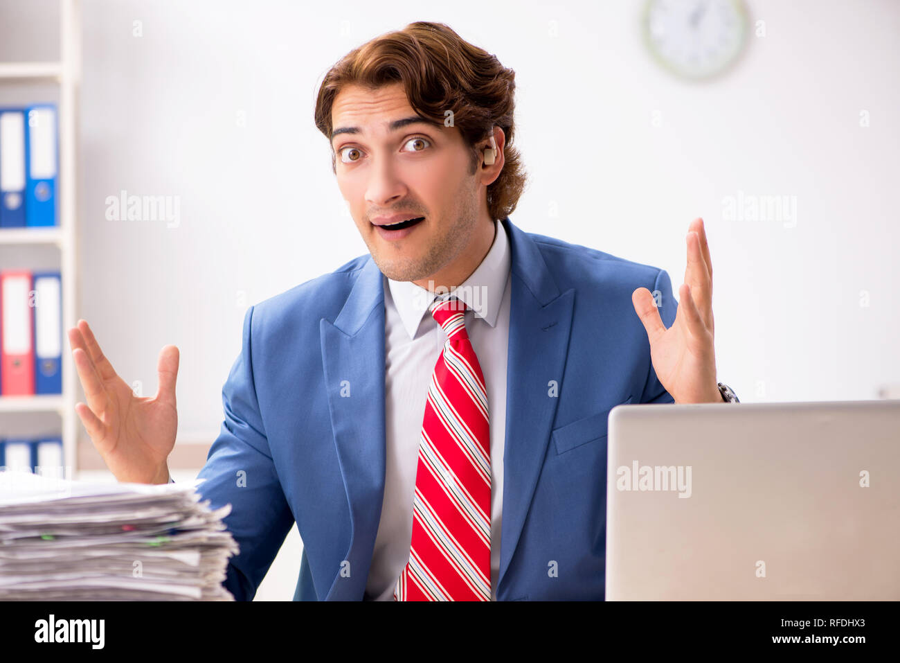 Deaf employee using hearing aid in office Stock Photo - Alamy