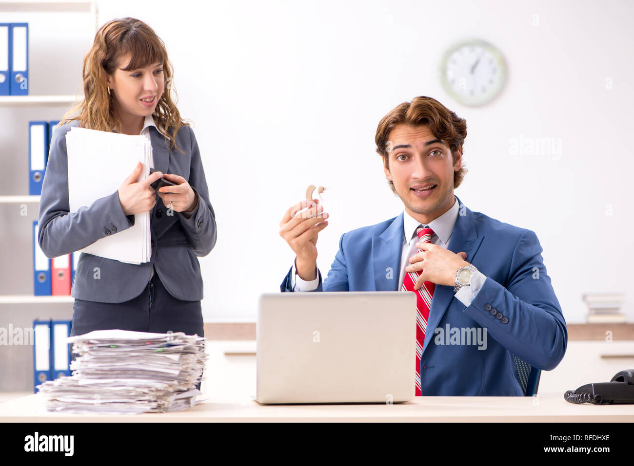 Deaf employee using hearing aid talking to boss Stock Photo - Alamy
