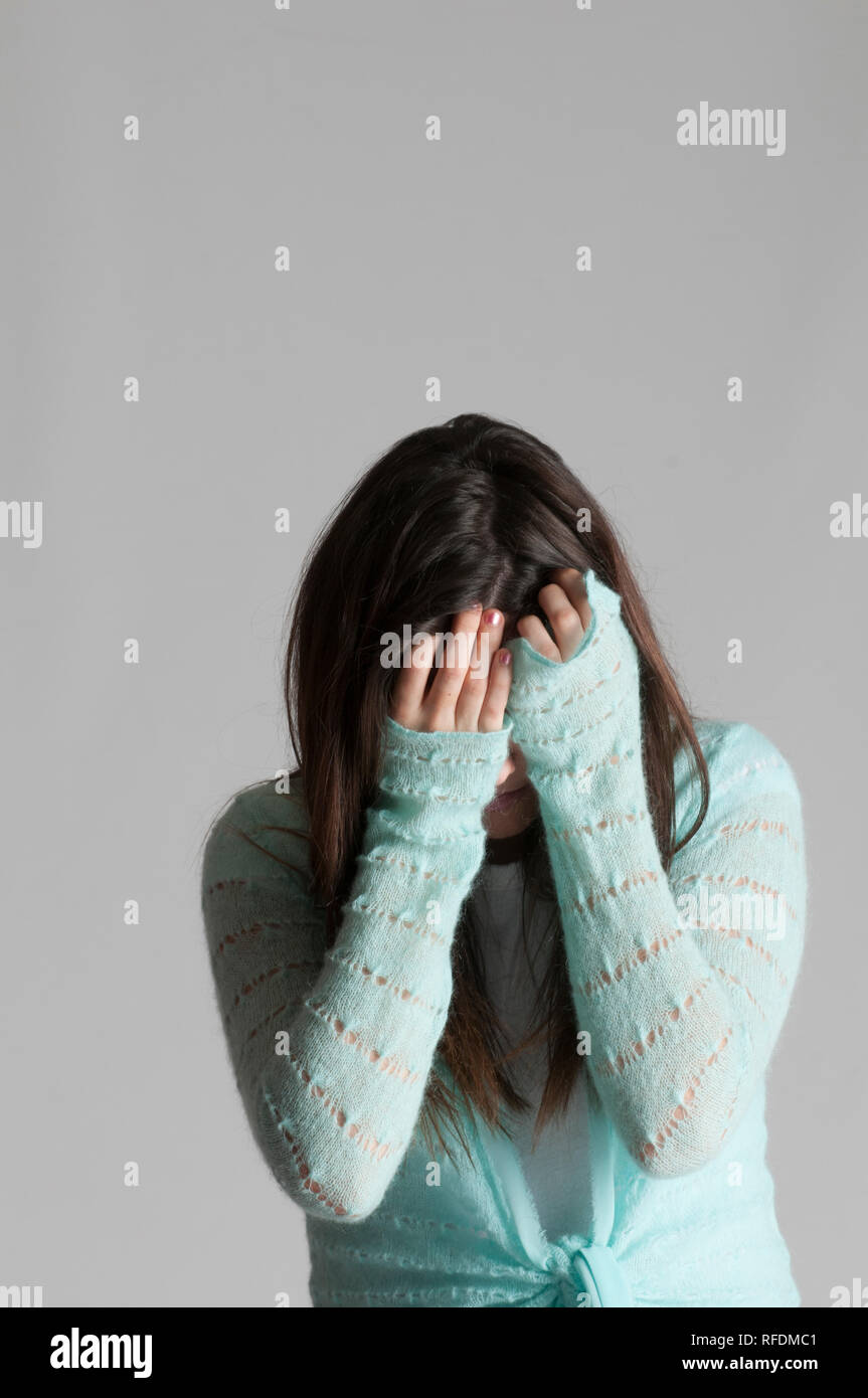 Scared young woman hiding face with hands crying Stock Photo - Alamy