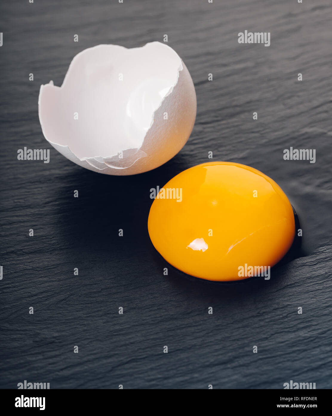 chicken egg yolk closeup on black stone background Stock Photo - Alamy