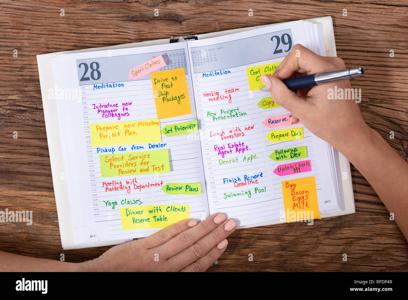 Overhead View Of A Businesswoman Writing Schedule In The Diary With Pen ...