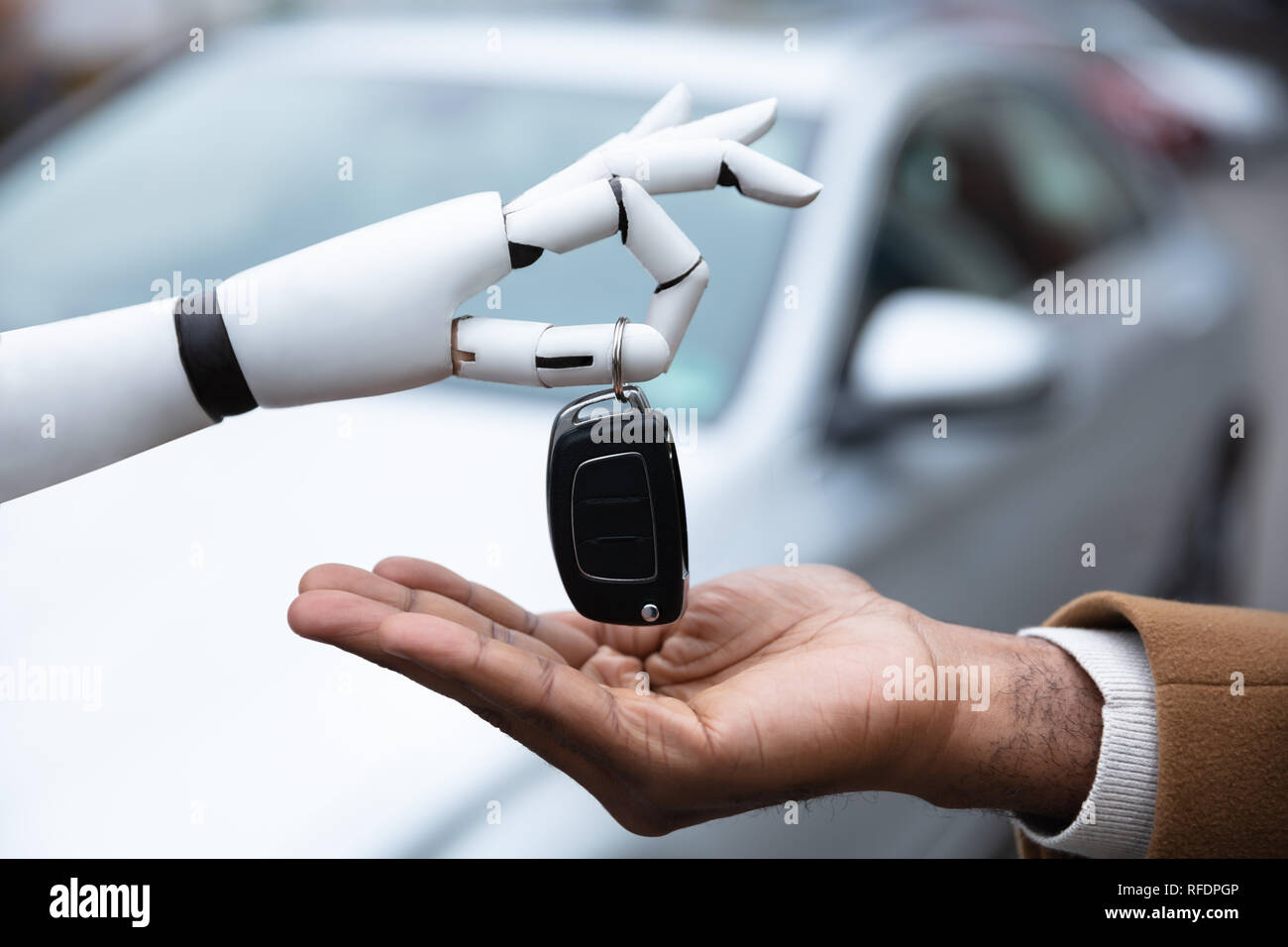 Close-up Of A Robot's Hand Giving Car Key To Man Stock Photo - Alamy