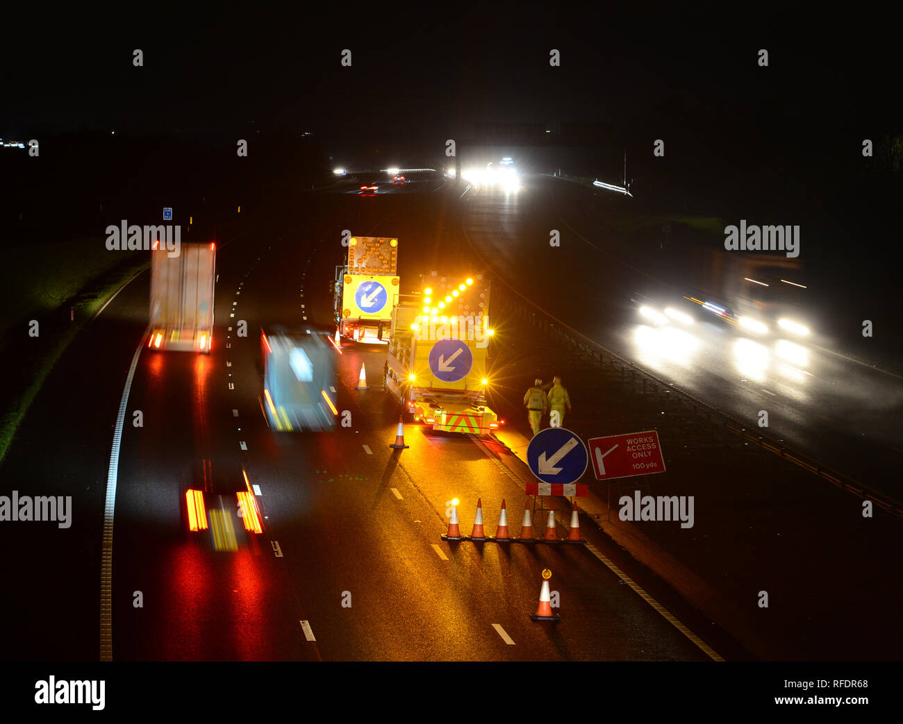 road workers with warning vehicles with flashing arrows closing lane at ...