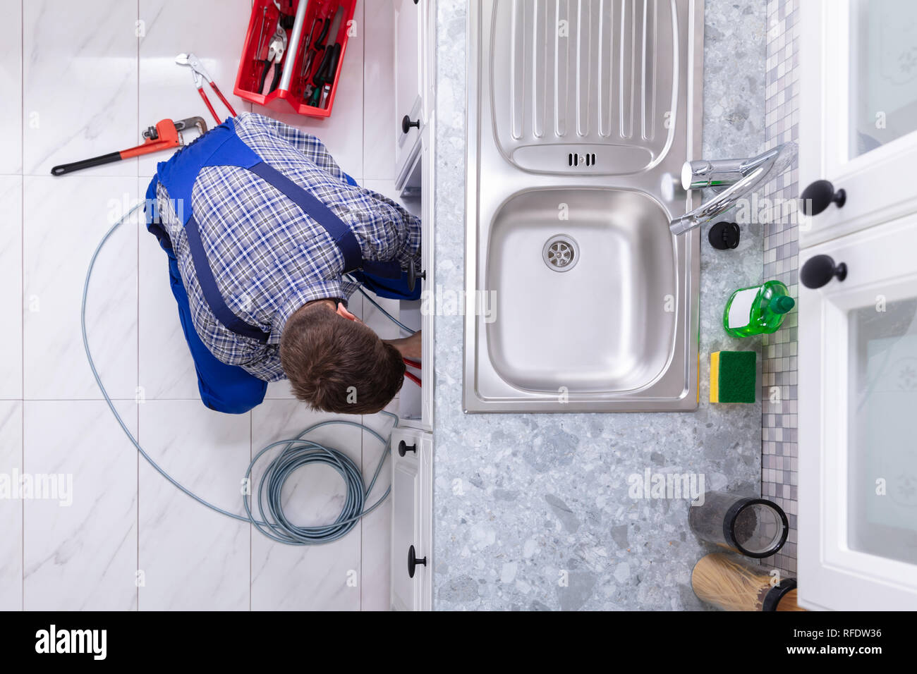 Young Male Plumber Cleaning Clogged Sink Pipe In Kitchen Stock Photo ...