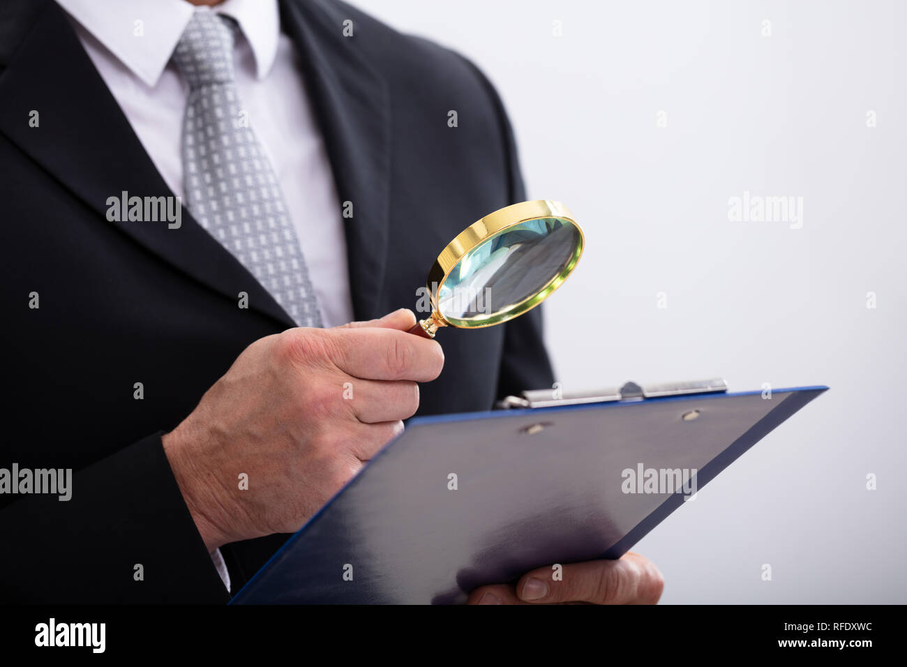 Close-up Of Businessman Analyzing Document Through Magnifying Glass At ...