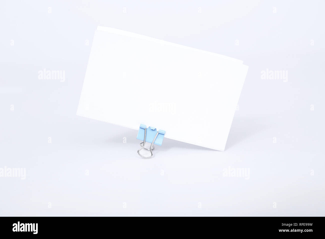 Portrait of white greeting card with attach paper clip. Isolated on the ...