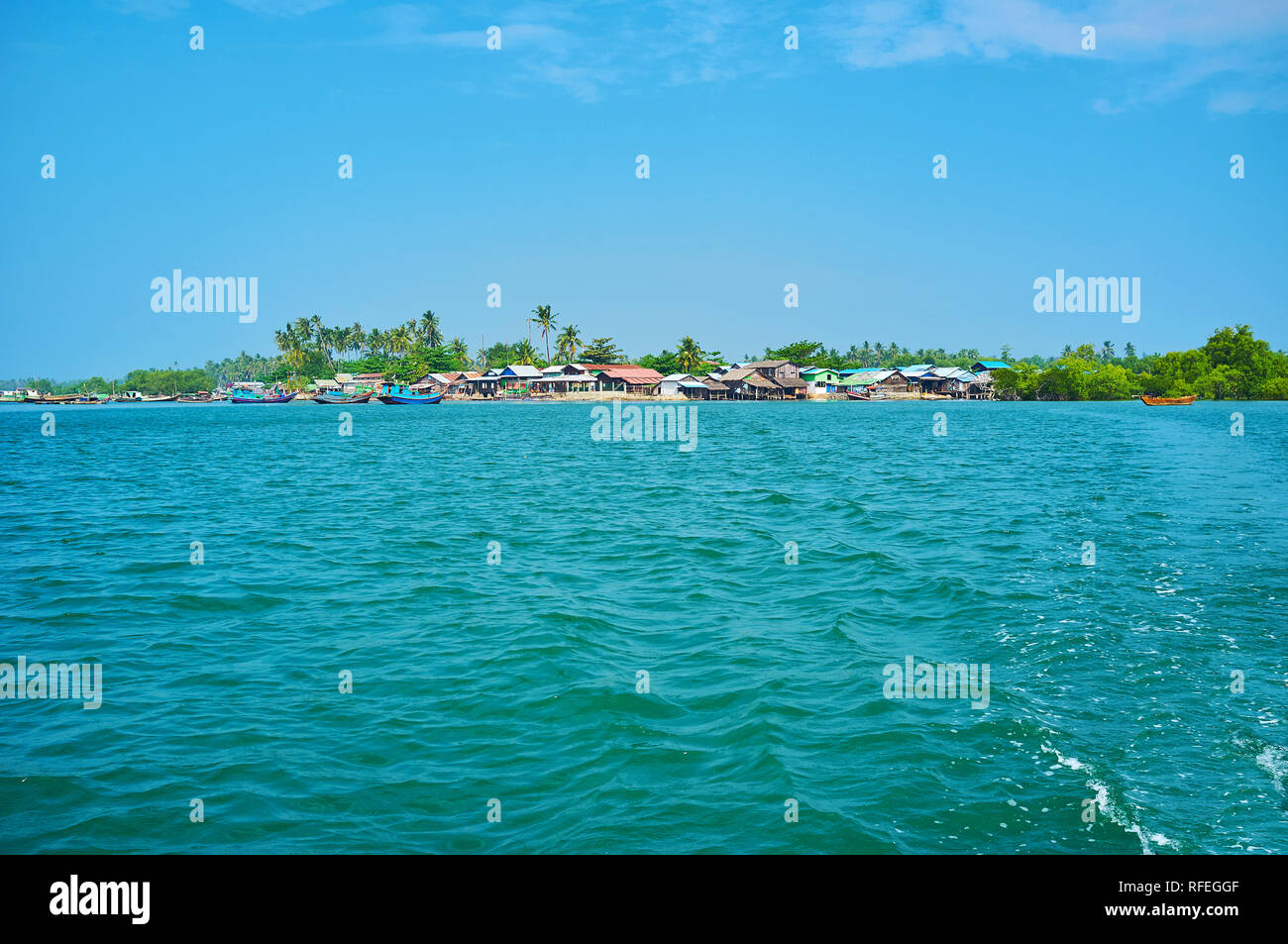 The colored huts of Chaung Tha fishing village among the lush mangrove ...