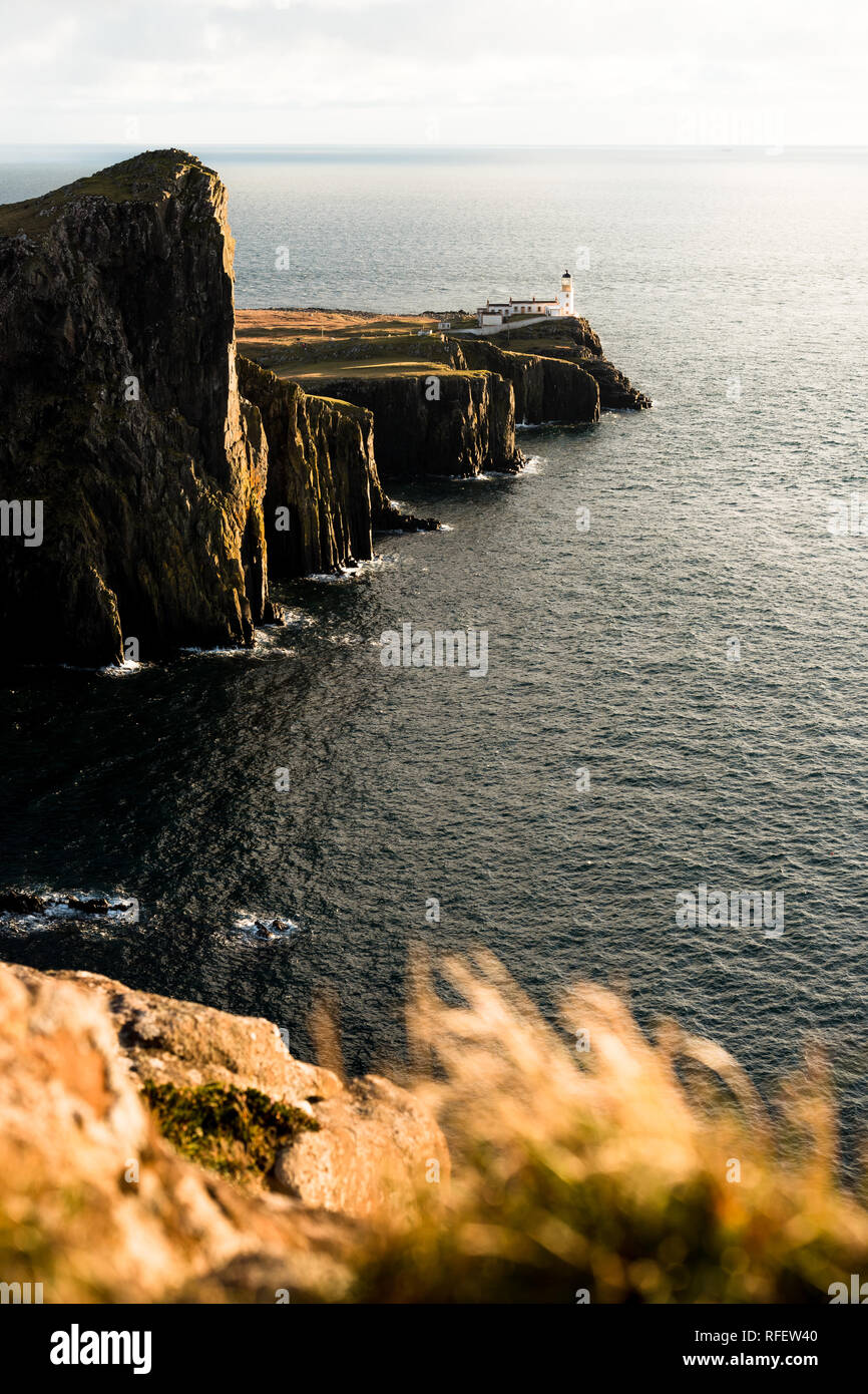 Sunset at Neist Point Lighthouse at the coastline of Skye with grass ...