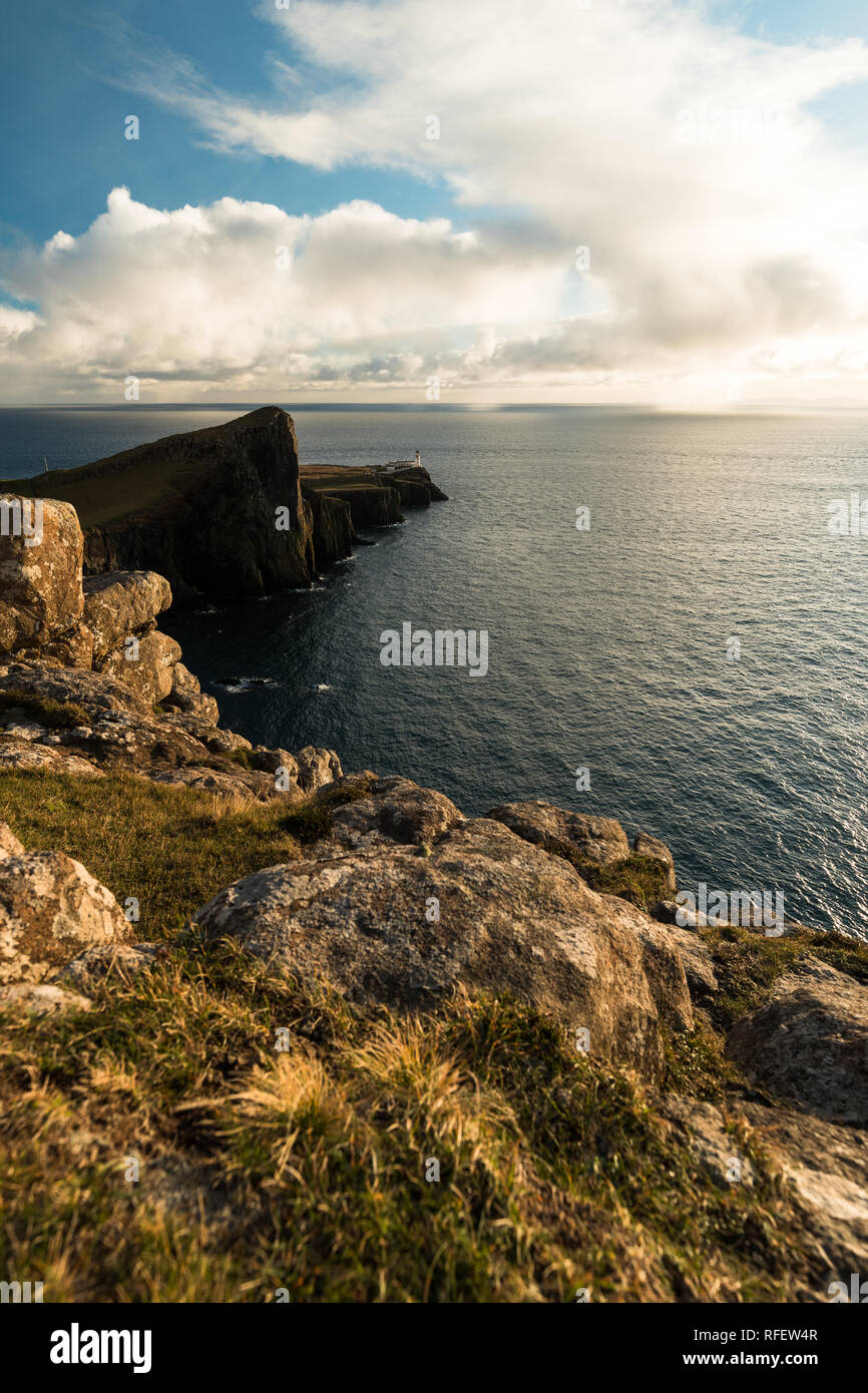 Sunset at Neist Point Lighthouse with rocky shore, dramatic sky and sun ...