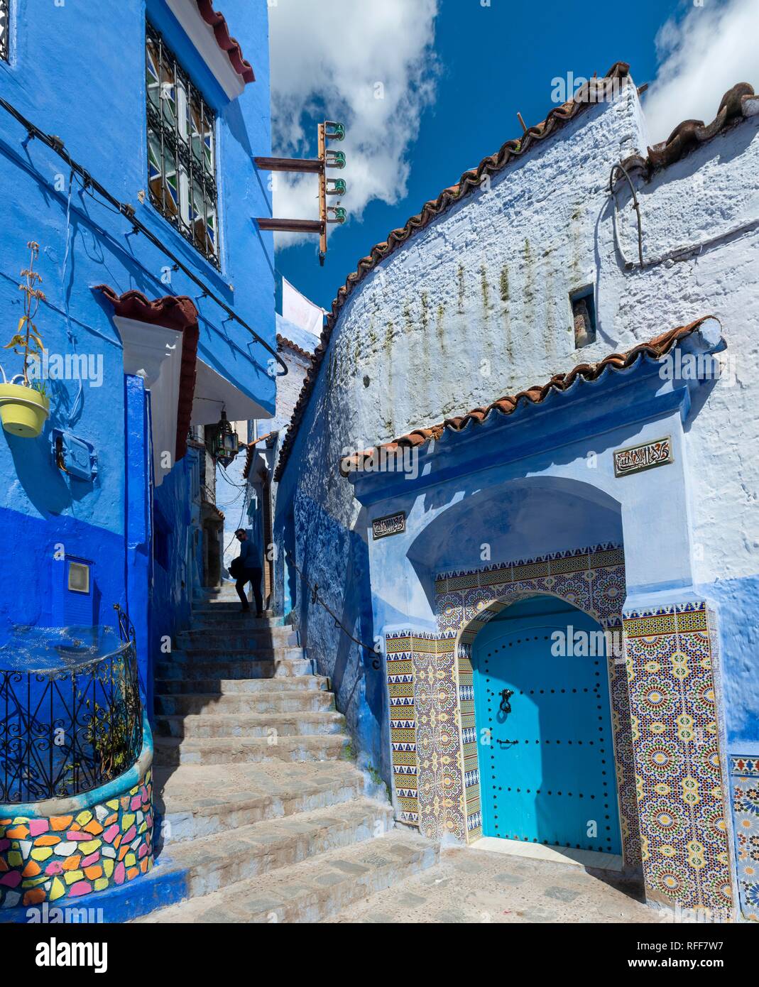 Narrow alley, blue entrance door and colorful tiles, blue house, medina ...