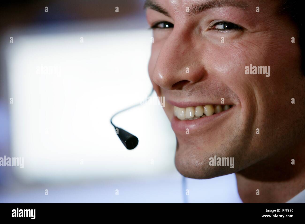 DEU, Germany : Man with headset in front of a computer screen, on the ...